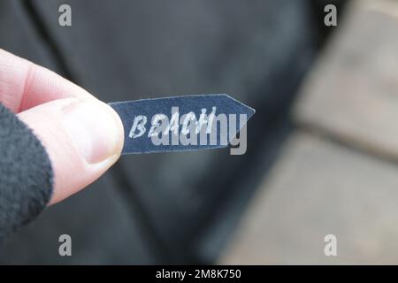 Beach idea. A hand holds a pointer with the inscription beach on a ...