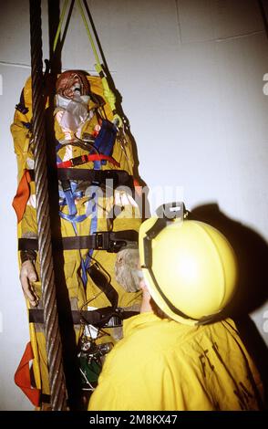 Brian Kelly, a fireman with the 90th CES, hangs head first down a ...