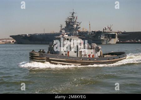 The large harbor tug Anoka (YTB-810) assist the guided missile cruiser ...