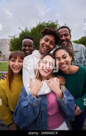 Multiracial group of young people hugging and embracing together ...