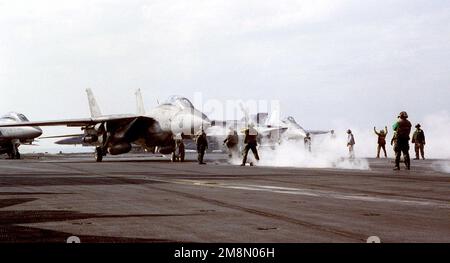 US Navy An F-14 Tomcat is directed to the steam-powered catapult prior ...
