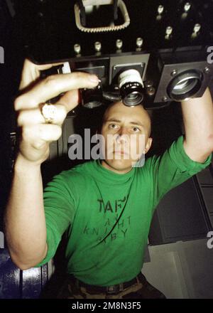 Photographer's Mate 3rd Class (PH3) Jason Stiles removes a panel from ...