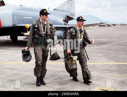 A pilot and radar intercept officer from Fighter Squadron 143 (VF-143) sit in the cockpit of ...
