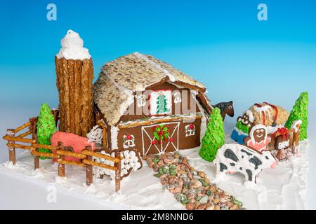 Front side of a homemade gingerbread barn with silo, farm animals, girl ...