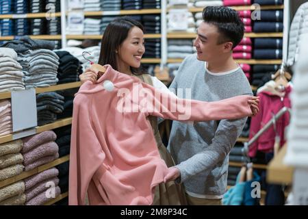 A young couple of choose and buy clothes Stock Photo - Alamy