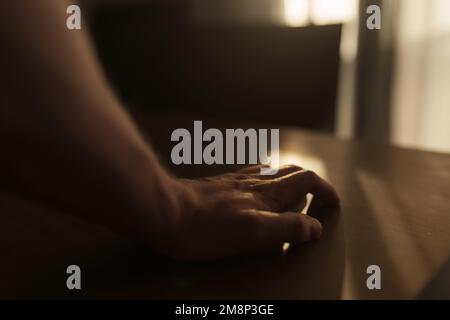 man hand touches black walnut dining table fingertapping, shallow focus ...
