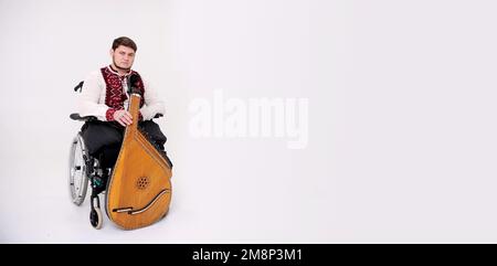 handsome young man with kobza musical instrument in hands sits on white ...
