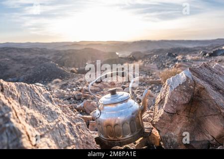 Traditional Moroccan mint tea prepared on the fire on top of a mountain ...