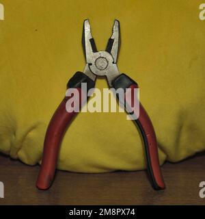 Pliers Open metal nippers with a red and green handle isolated on black ...