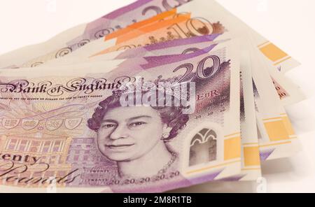 close-up of a pile of ten and twenty pound sterling notes with a brown ...