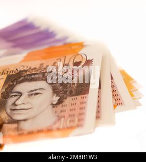 close-up of a pile of ten and twenty pound sterling notes with a brown ...