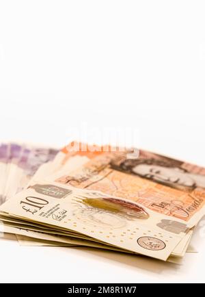 close-up of a pile of ten and twenty pound sterling notes with a brown ...