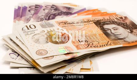 close-up of a pile of ten and twenty pound sterling notes with a brown ...