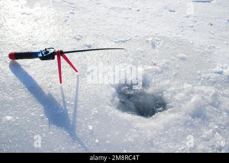 Winter fishing. Fishing rod stands on the ice. Fishing theme Stock ...