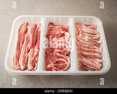 Assorted pork cuts on trays for packaging Stock Photo - Alamy