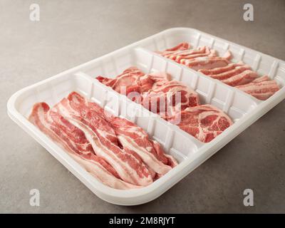 Assorted pork cuts on trays for packaging Stock Photo - Alamy