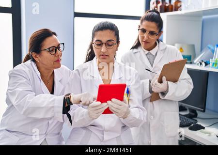 Three woman scientists using touchpad write on checklist at laboratory Stock Photo - Alamy