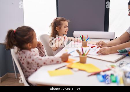Two kids preschool students sitting on table drawing on paper at ...