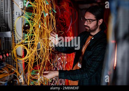 Side view portrait of bearded system administrator setting up server ...
