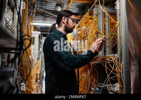 Side view portrait of bearded system administrator setting up server ...