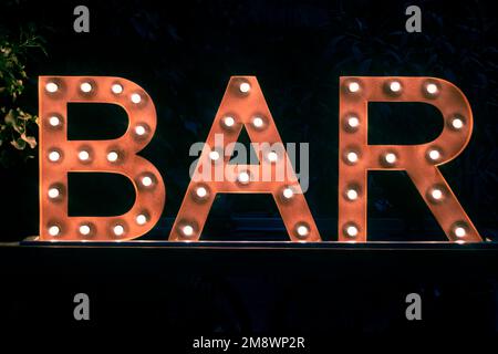 B A R letters lighted by spotlights on a dark black background Stock ...