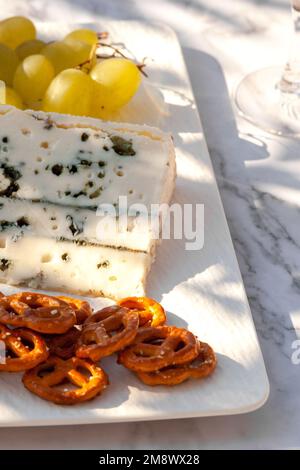roquefort cheese served with green grapes and snacks outdoors, hard ...