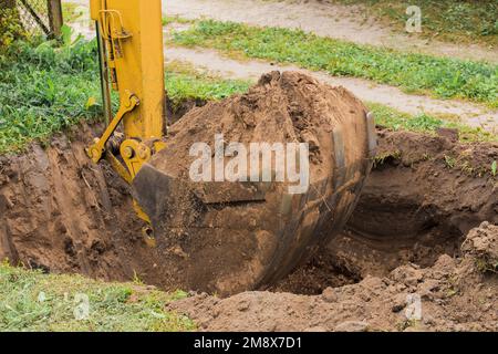 Excavating large hole in field using a mechanical excavator England UK ...