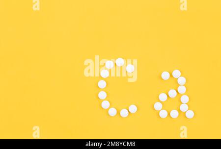Flat lay composition with calcium supplement pills on light green ...
