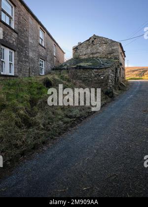 Cluster of farm buildings with bright blue sky ,distant hills and rough ...