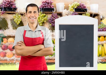 portrait of shopman at the fruits store with crossing arms with ...