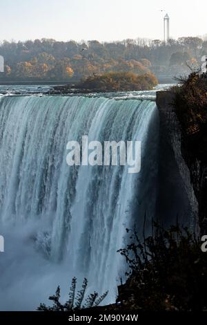 A vertical aerial shot of Niagara Falls and people admiring the view in ...