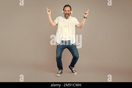 Happy old rocker sing along rock music playing in headphones making ...
