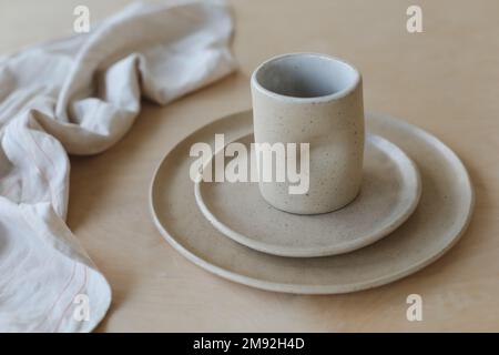 Beige ceramic plate on a wooden table top view. minimalist handmade ...