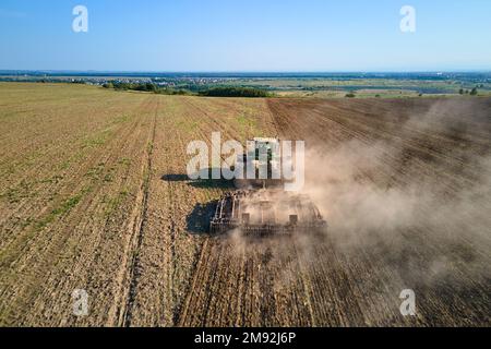 Aerial view of tractor plowing agriculural farm field preparing soil ...