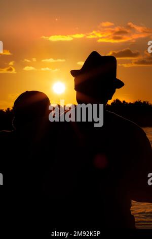 Father and son looking at sunset Stock Photo - Alamy
