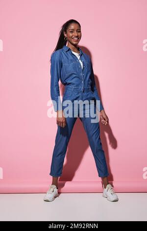 Optimistic young African American female model smiling looking at ...