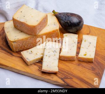 Italian cheese collection, yellow taleggio cheese with black truffles ...