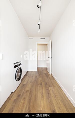Interior of light laundry room with washing machine, basket and dryer ...