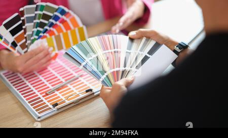 Designer helps client choose colors for project from variety Stock ...