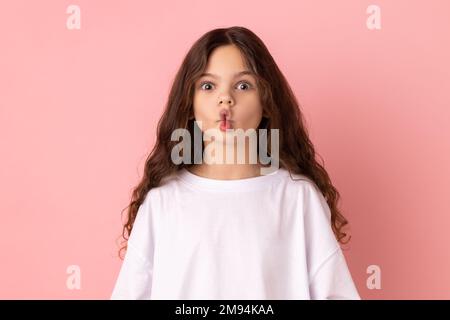 Little girl, silly and goofy face on green screen with facial expressions against a studio ...