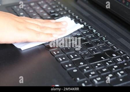 Clean computer keyboard with antibacterial wet towel, virus prevention ...