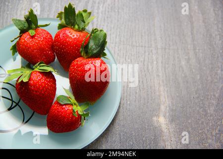 Select fruit, red strawberries in plastic packaging, vintage gray wood ...