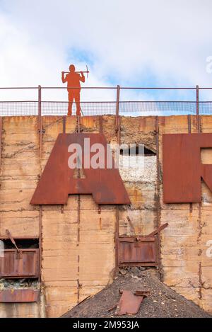 A close-up of the large COBAR sign and a silhouetted iron mining figure ...