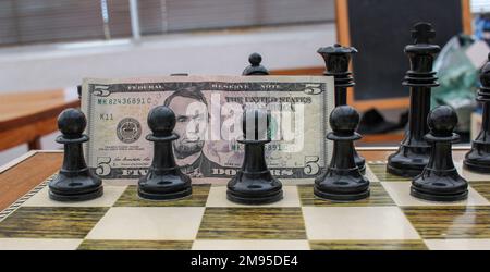 dollar bill among black chess pieces Stock Photo - Alamy