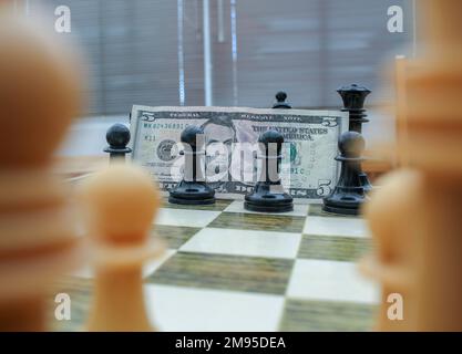 dollar bill among black chess pieces Stock Photo - Alamy