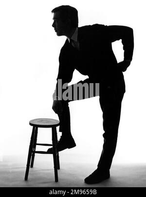 A young man poses with a stool Stock Photo - Alamy