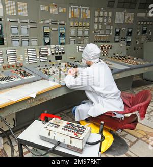 Chernobyl reactor 3 control room. Worker sat at the control panel of ...