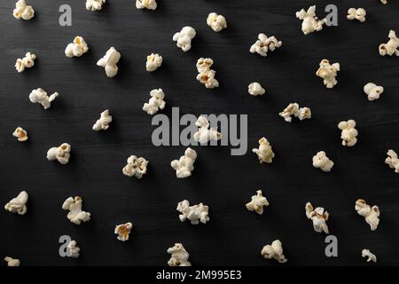Top view of a group of popcorn, arranged in a pattern, on a black ...