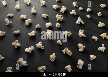 Top view of a group of popcorn, arranged in a pattern, on a black ...