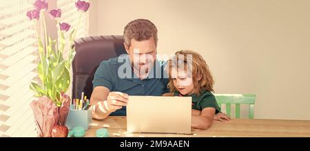 bearded dad or school private tutor teaching boy son with modern laptop ...